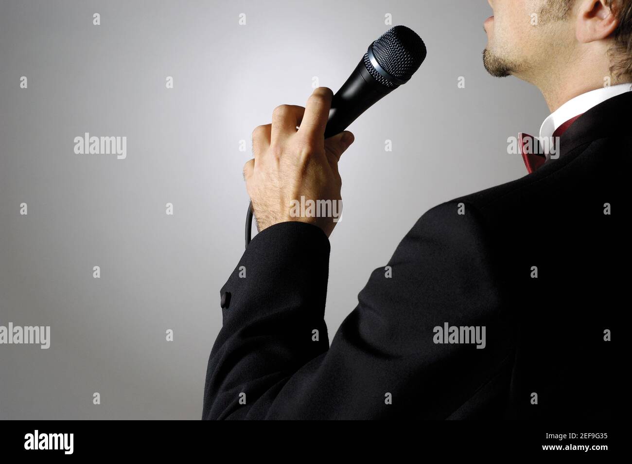 Mid section view of a young man singing into a microphone Stock Photo ...