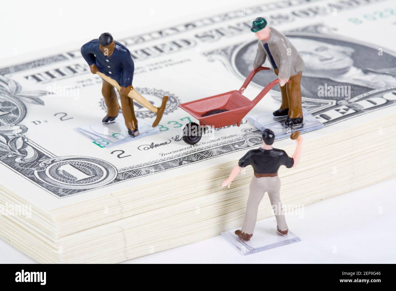 Figurines of manual workers with US paper currency Stock Photo - Alamy