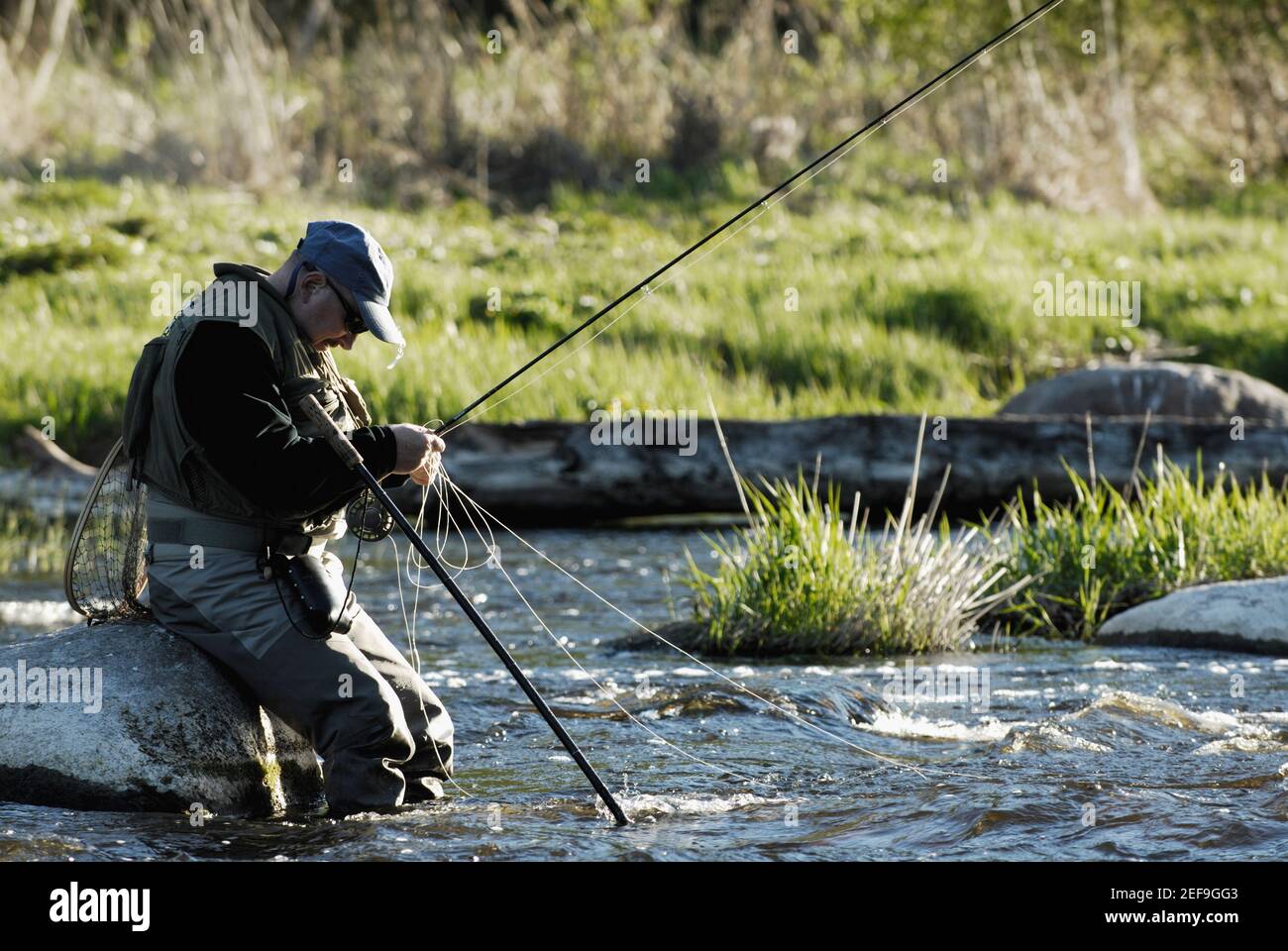 Side profile of a mature man fishing in the river Stock Photo - Alamy