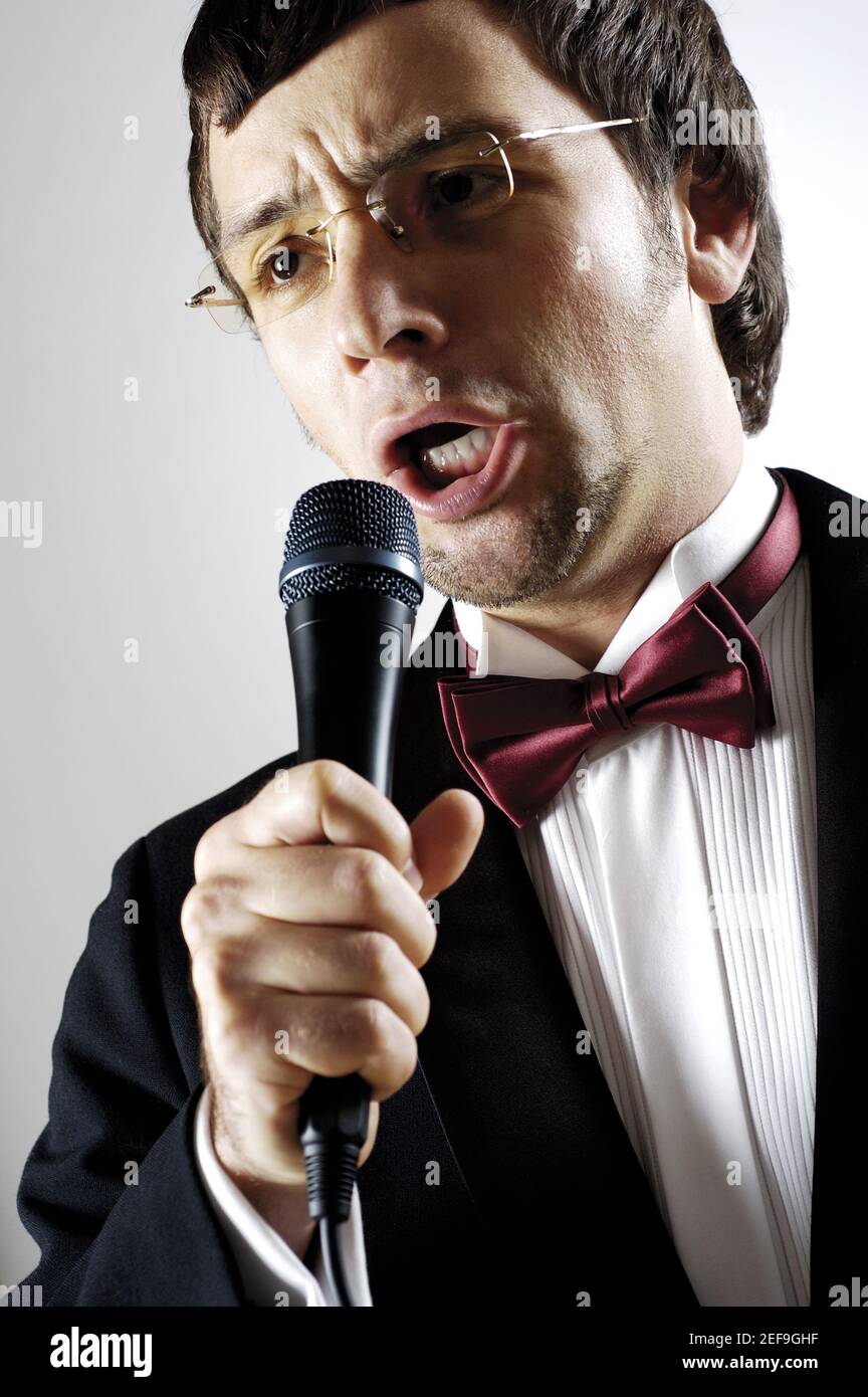 Close-up of a young man singing into a microphone Stock Photo - Alamy