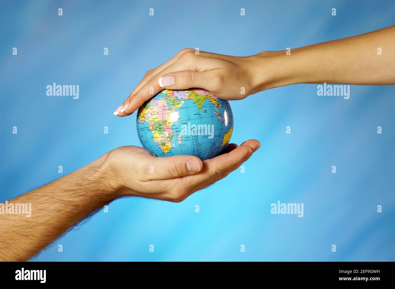Two people holding up globe hi-res stock photography and images - Alamy