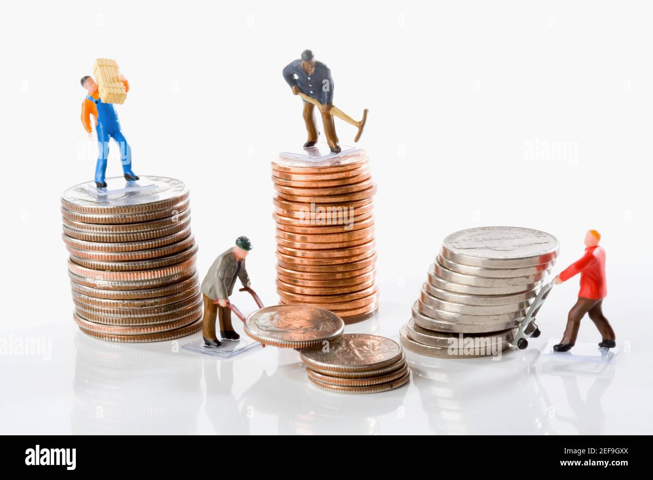 Figurines of manual workers with stacks of coins Stock Photo - Alamy