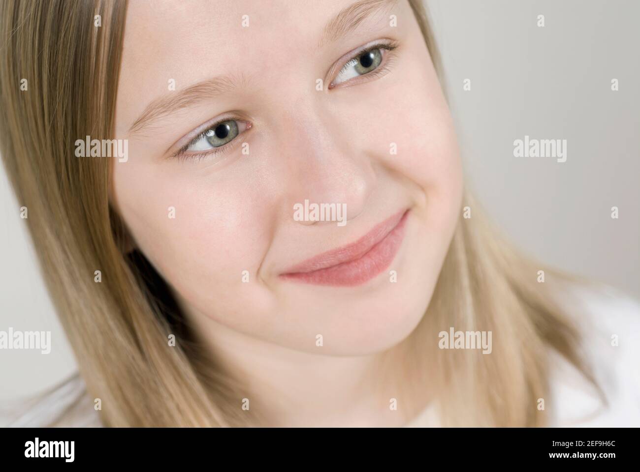 Close up of a girl smiling and thinking Stock Photo - Alamy