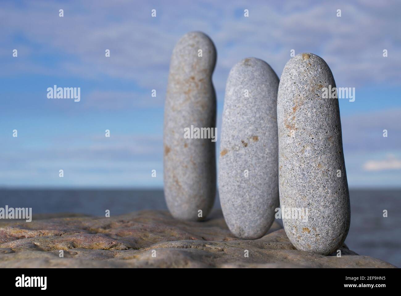 Three pebbles on a rock Stock Photo - Alamy