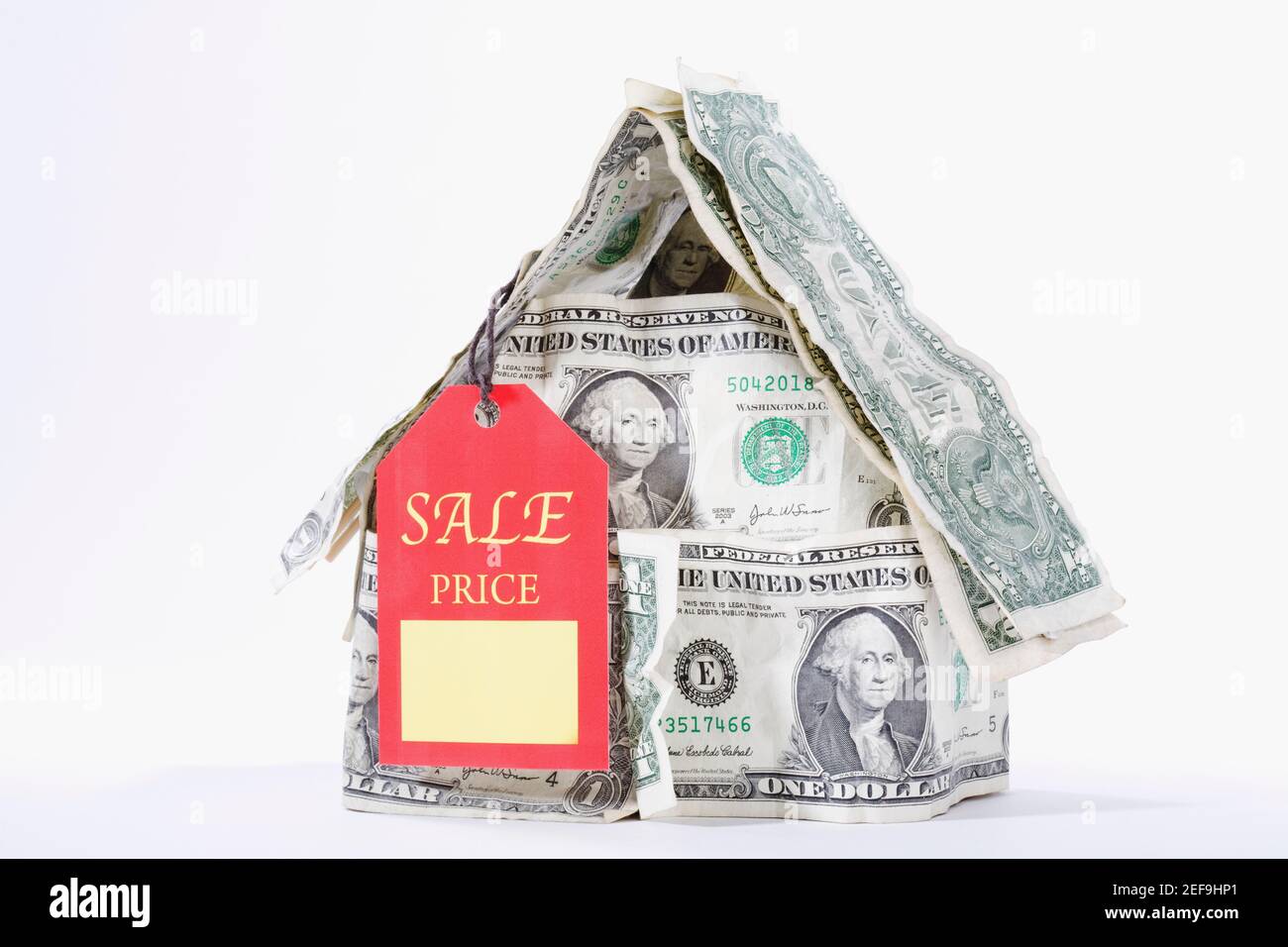 Sale tag attached with a miniature house made up of US dollar bills ...