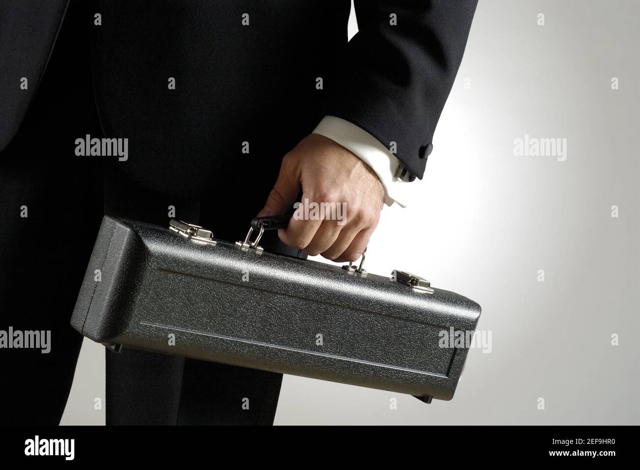 Mid section view of a man holding a case Stock Photo - Alamy