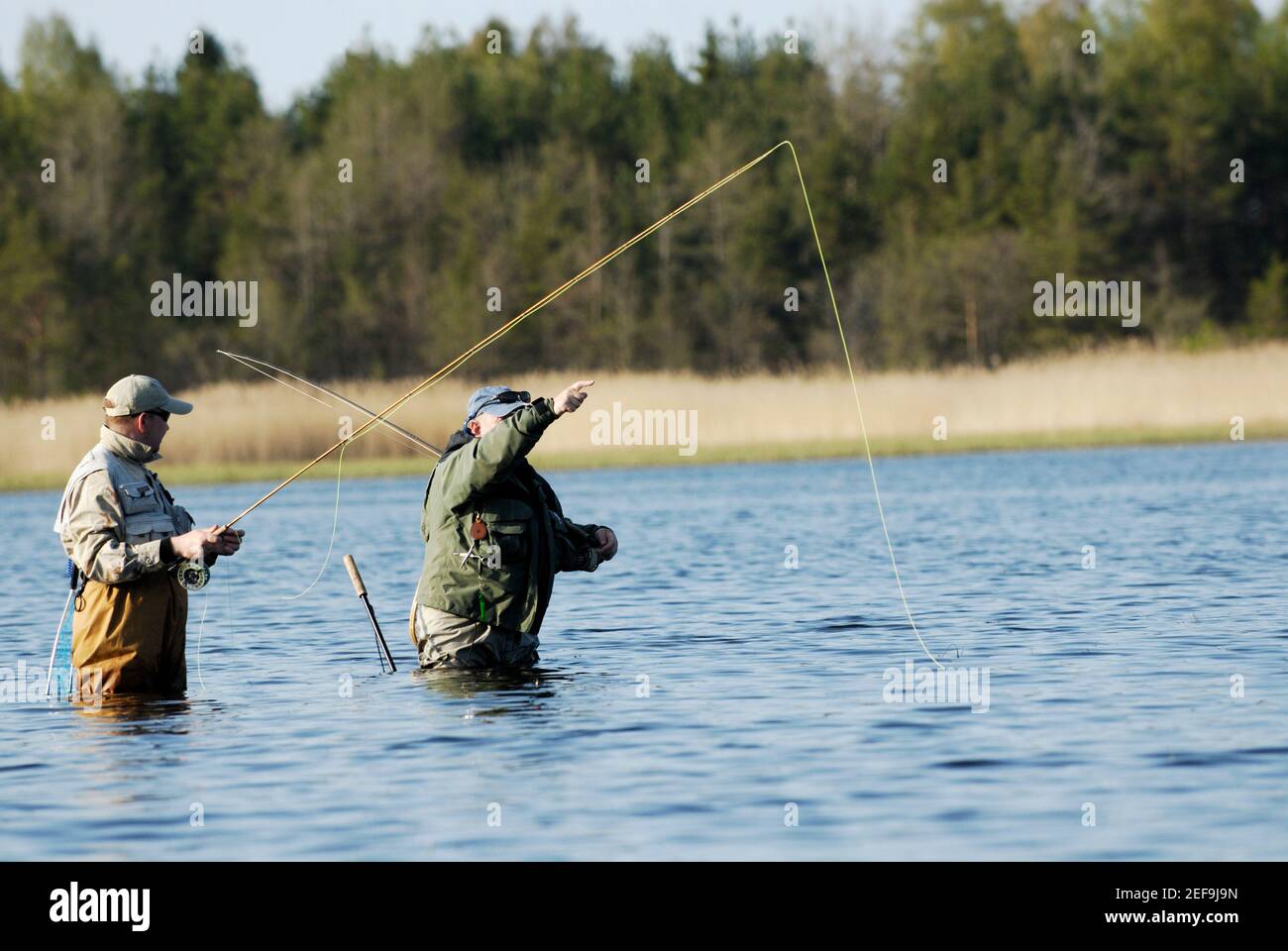 Side profile of two mature men fishing in the river Stock Photo - Alamy