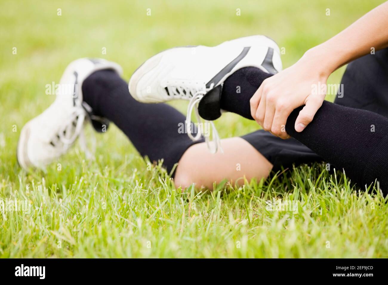 Low section view of a soccer player holding his leg Stock Photo - Alamy