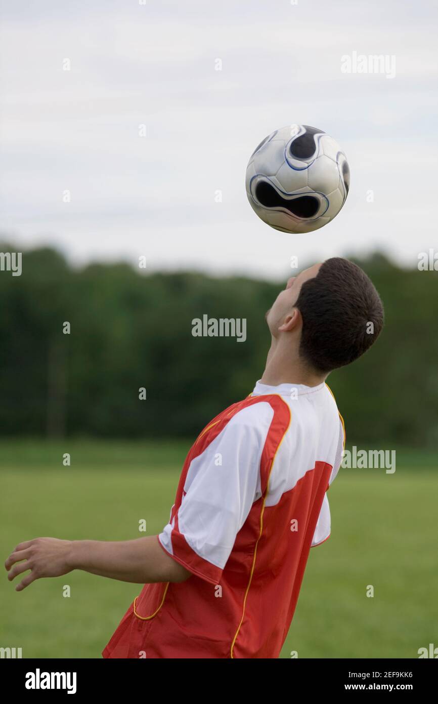 Side profile of a soccer player heading a ball Stock Photo - Alamy