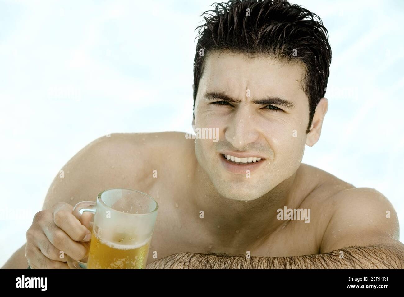 Portrait of a young man holding a mug of beer Stock Photo - Alamy