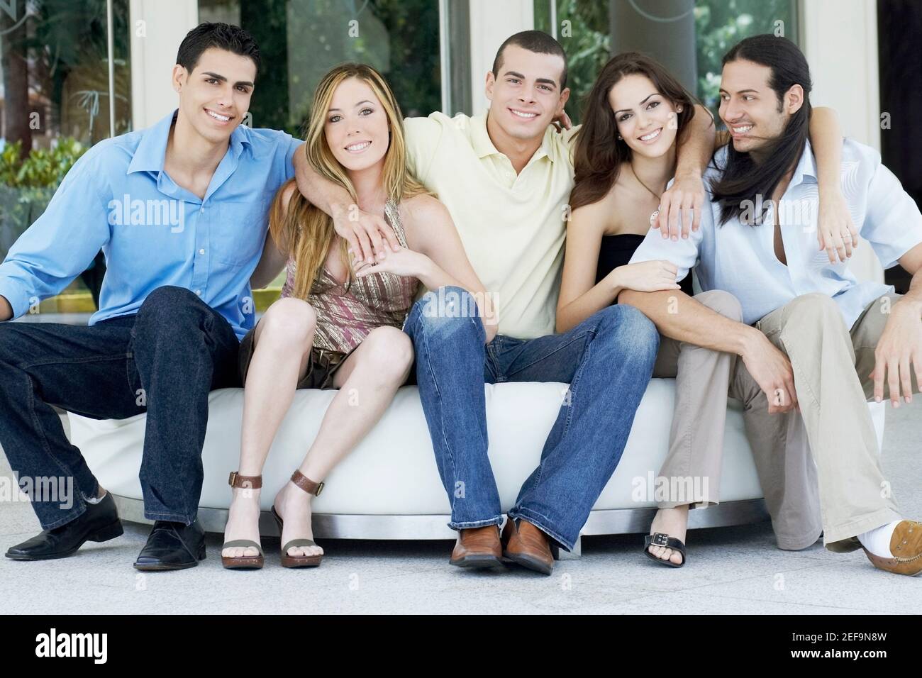Group of friends sitting together on a couch and smiling Stock Photo ...
