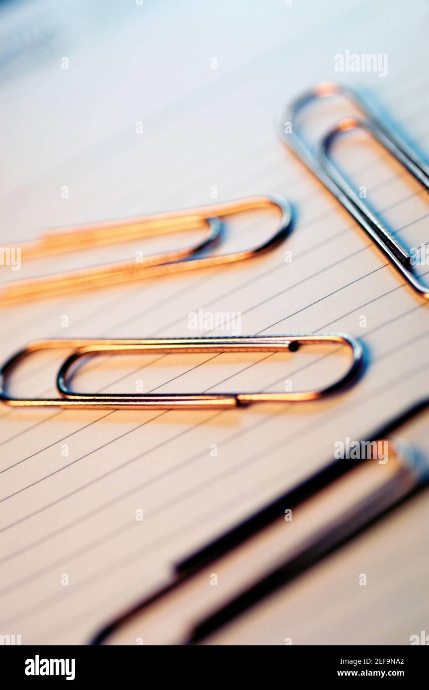 Paper clips and lined paper, close-up Stock Photo - Alamy