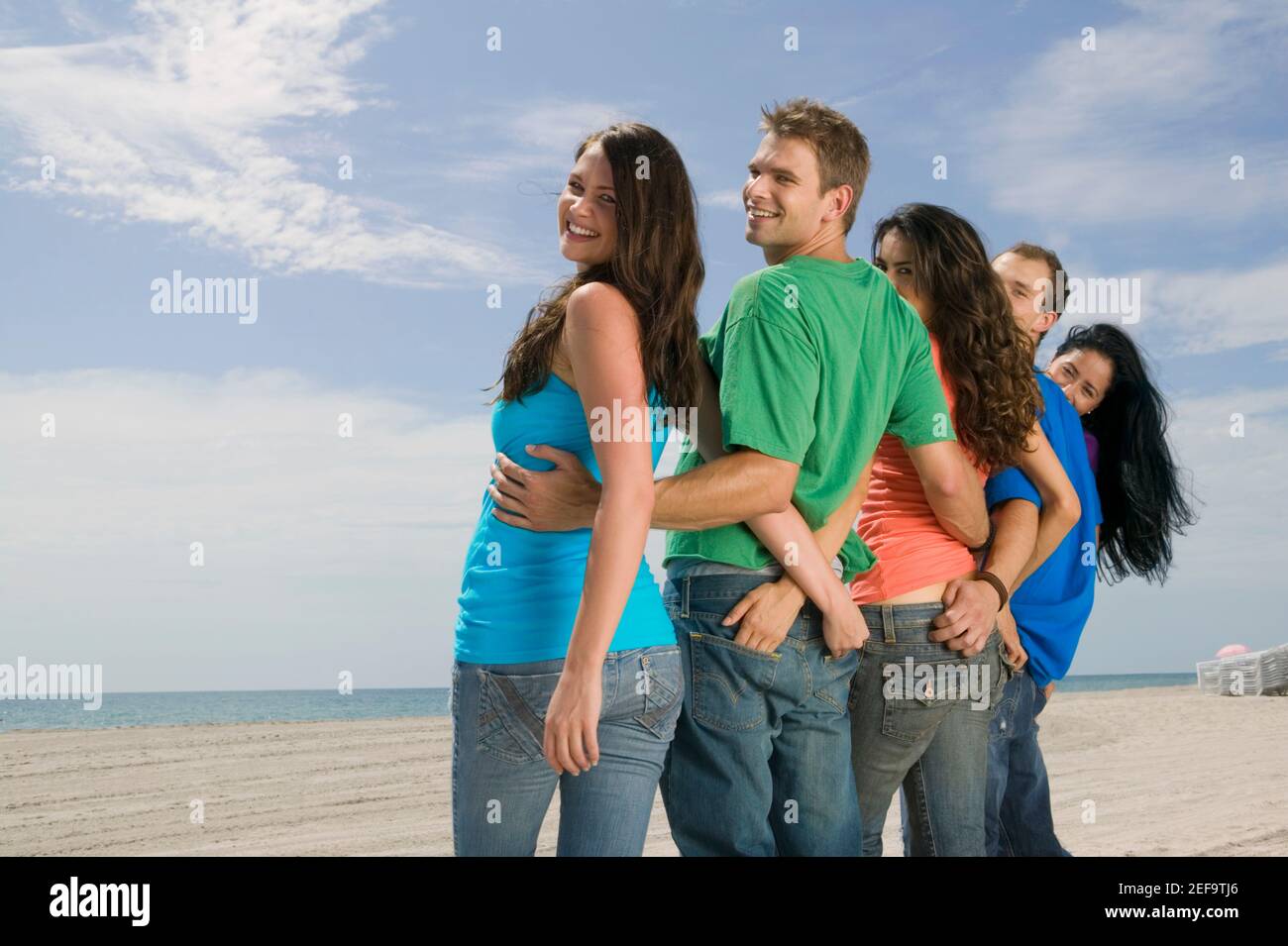 Rear view of five people standing on the beach Stock Photo - Alamy