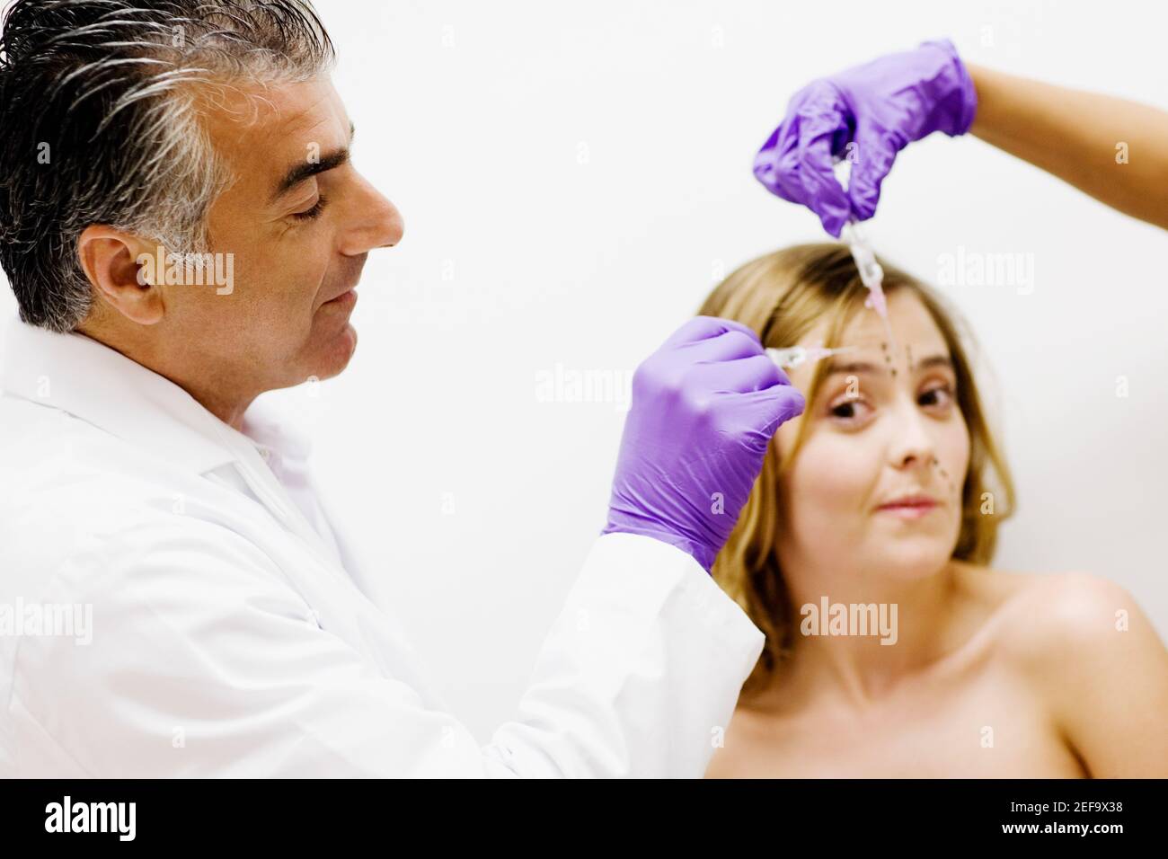 Male medical professional injecting patient hi-res stock photography ...