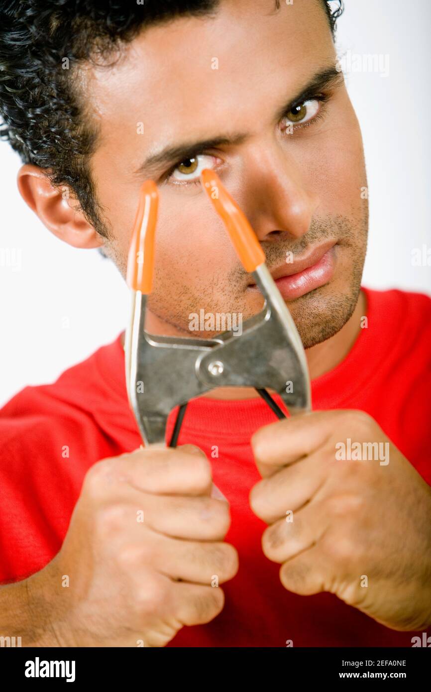 Portrait of a young man holding a clamp Stock Photo - Alamy