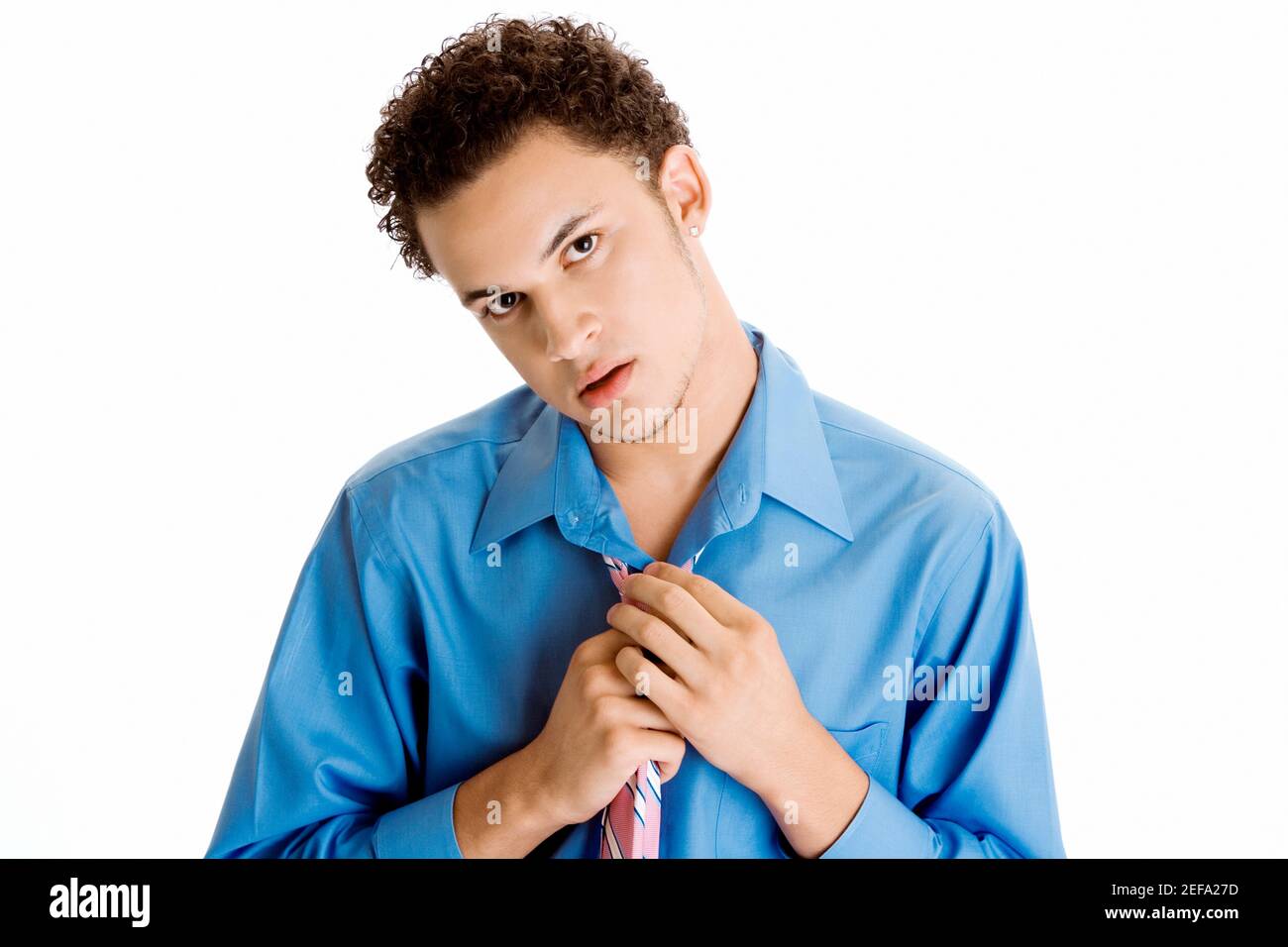 Portrait of a young man pulling his tie Stock Photo - Alamy