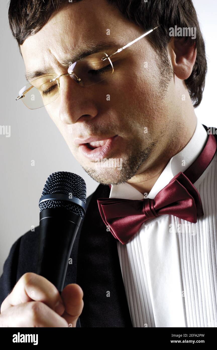 Close-up of a young man singing into a microphone Stock Photo - Alamy