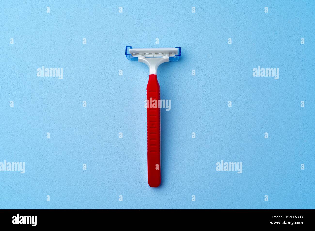Single disposable razor for women on blue background Stock Photo - Alamy