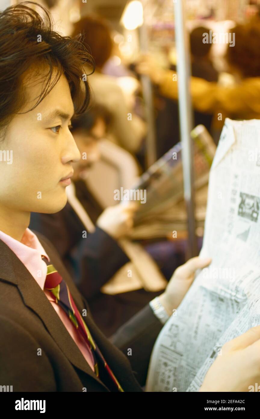 Asian man newspaper train hi-res stock photography and images - Alamy