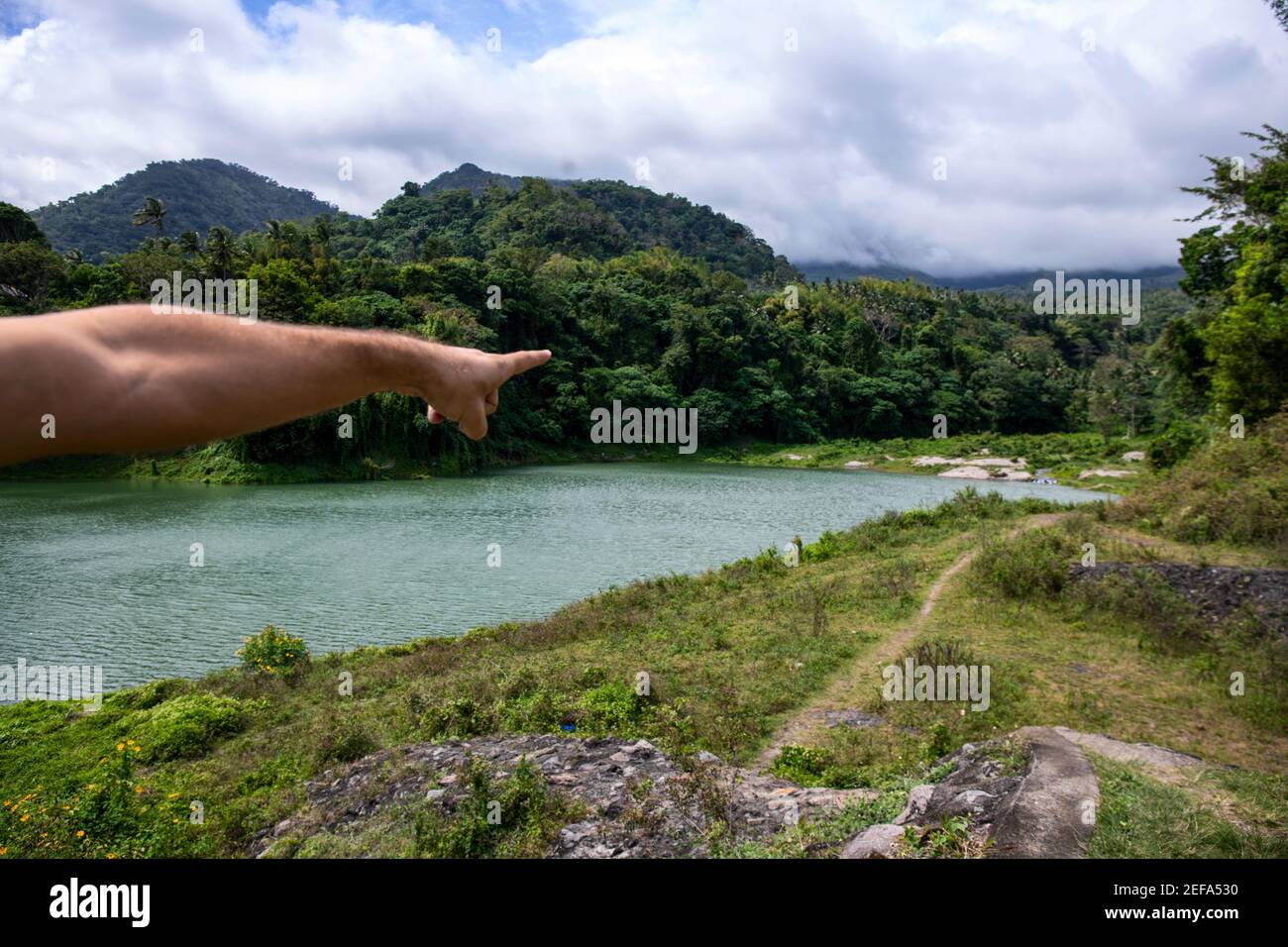 Man pointing finger on distant lake shore and forest. Natural tourism ...