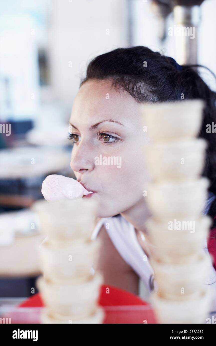 Young woman eating an ice-cream cone Stock Photo - Alamy