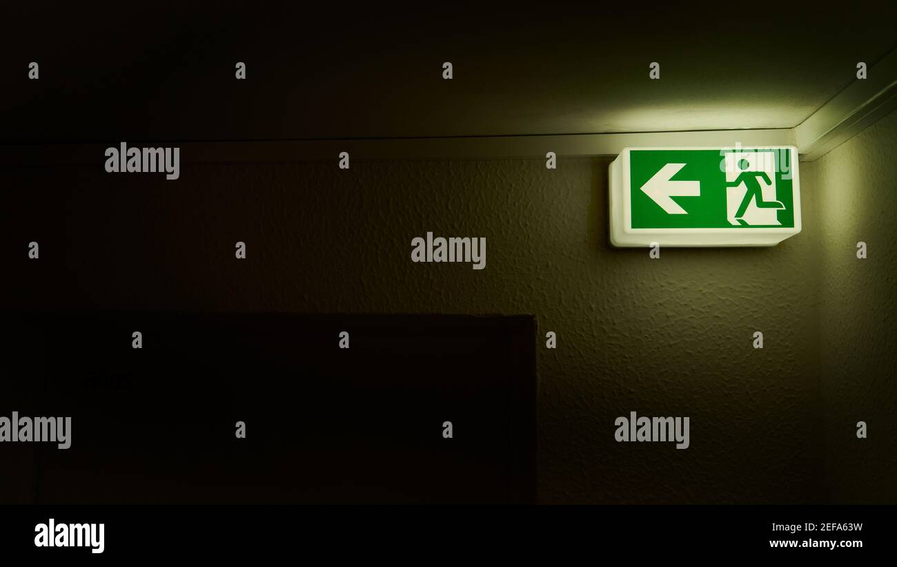 Luminous emergency exit symbol for fire safety in the house Stock Photo ...