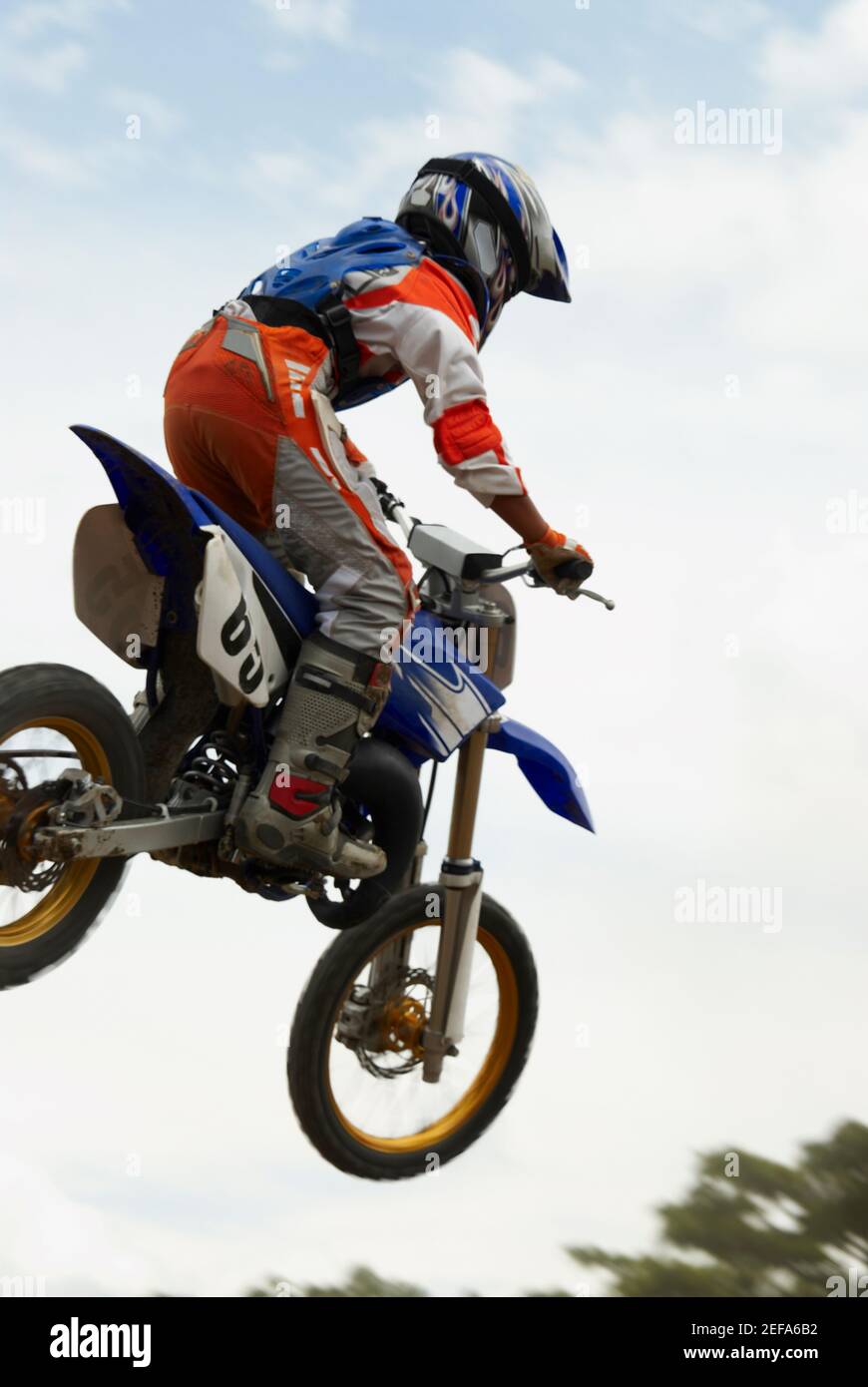 Low angle view of a motocross rider performing a jump on a motorcycle ...