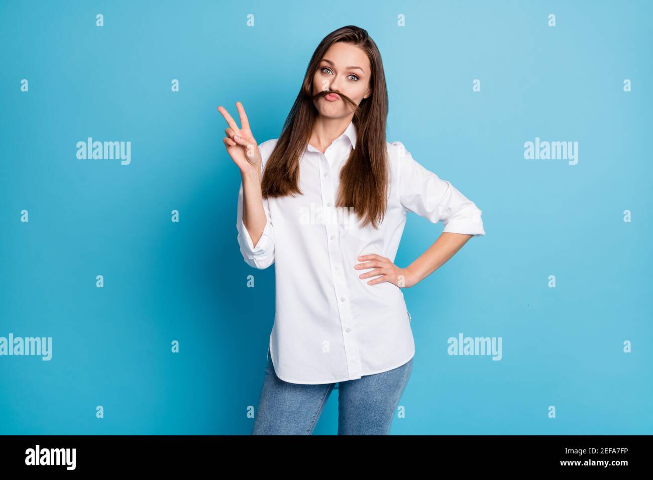 Photo of pretty lady playing long hairstyle curl making mustache showing v-sign wear shirt jeans ...
