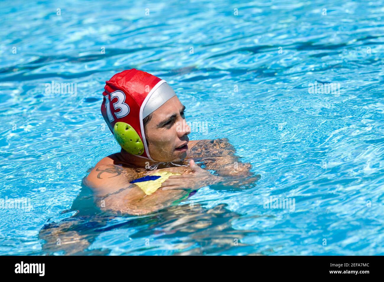 Side profile of a mid adult man playing water polo in a swimming pool ...