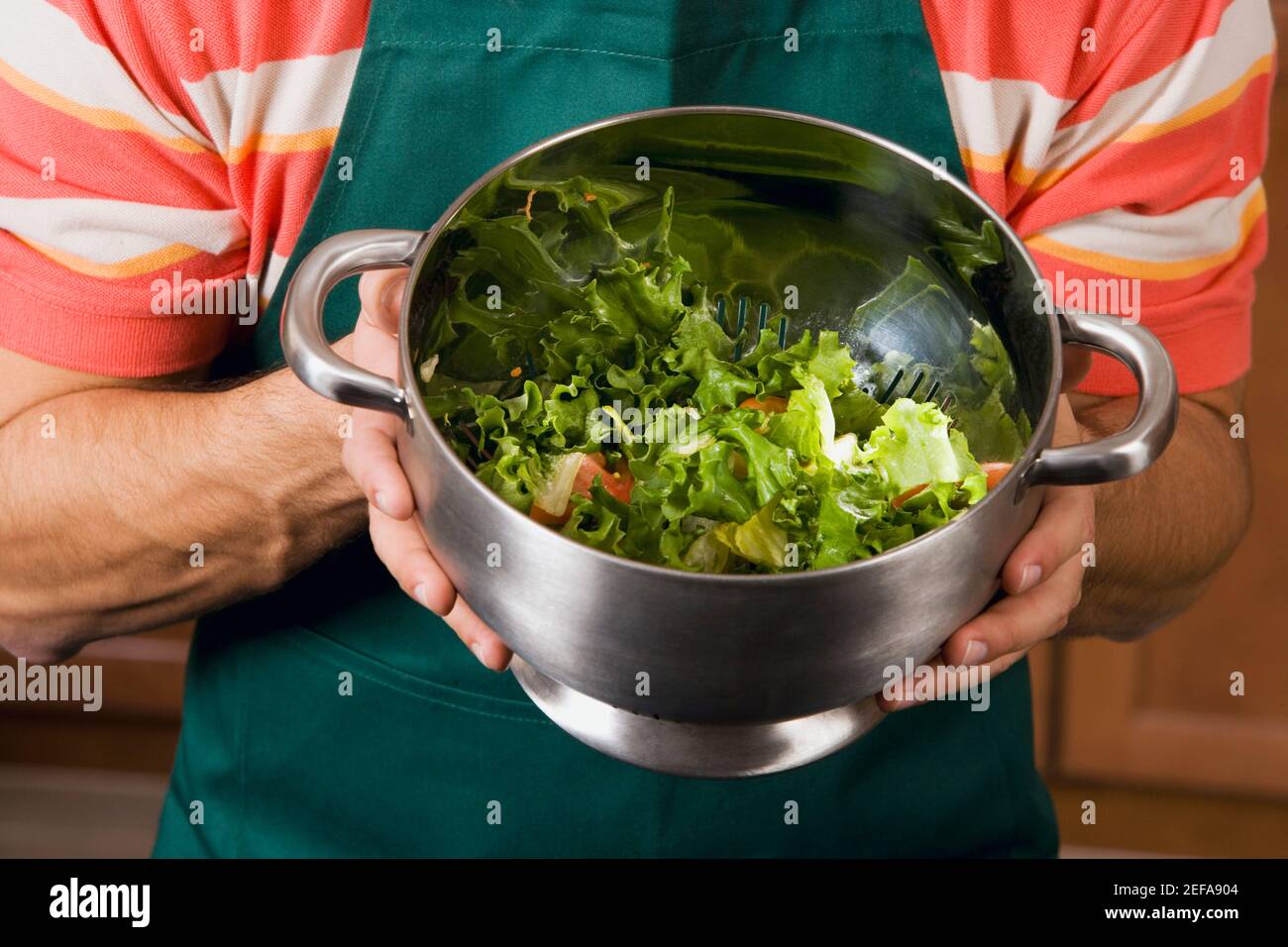 Mid section view of a man mixing salad in a colander Stock Photo - Alamy