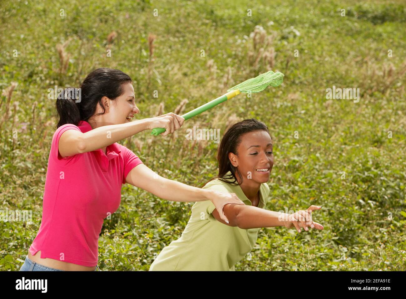 Two young women catching butterflies Stock Photo - Alamy