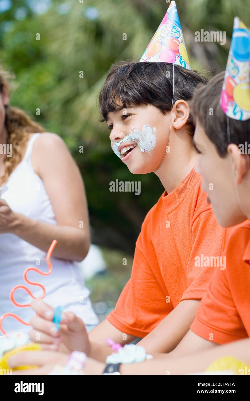 Side profile of two boys and a girl celebrating a birthday party Stock ...