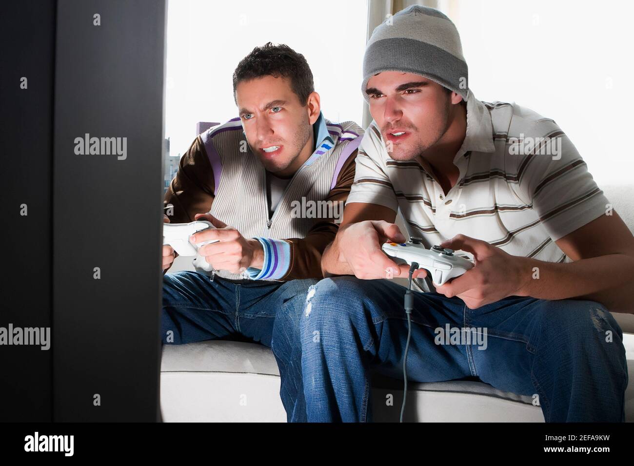 Two young men playing video game Stock Photo - Alamy