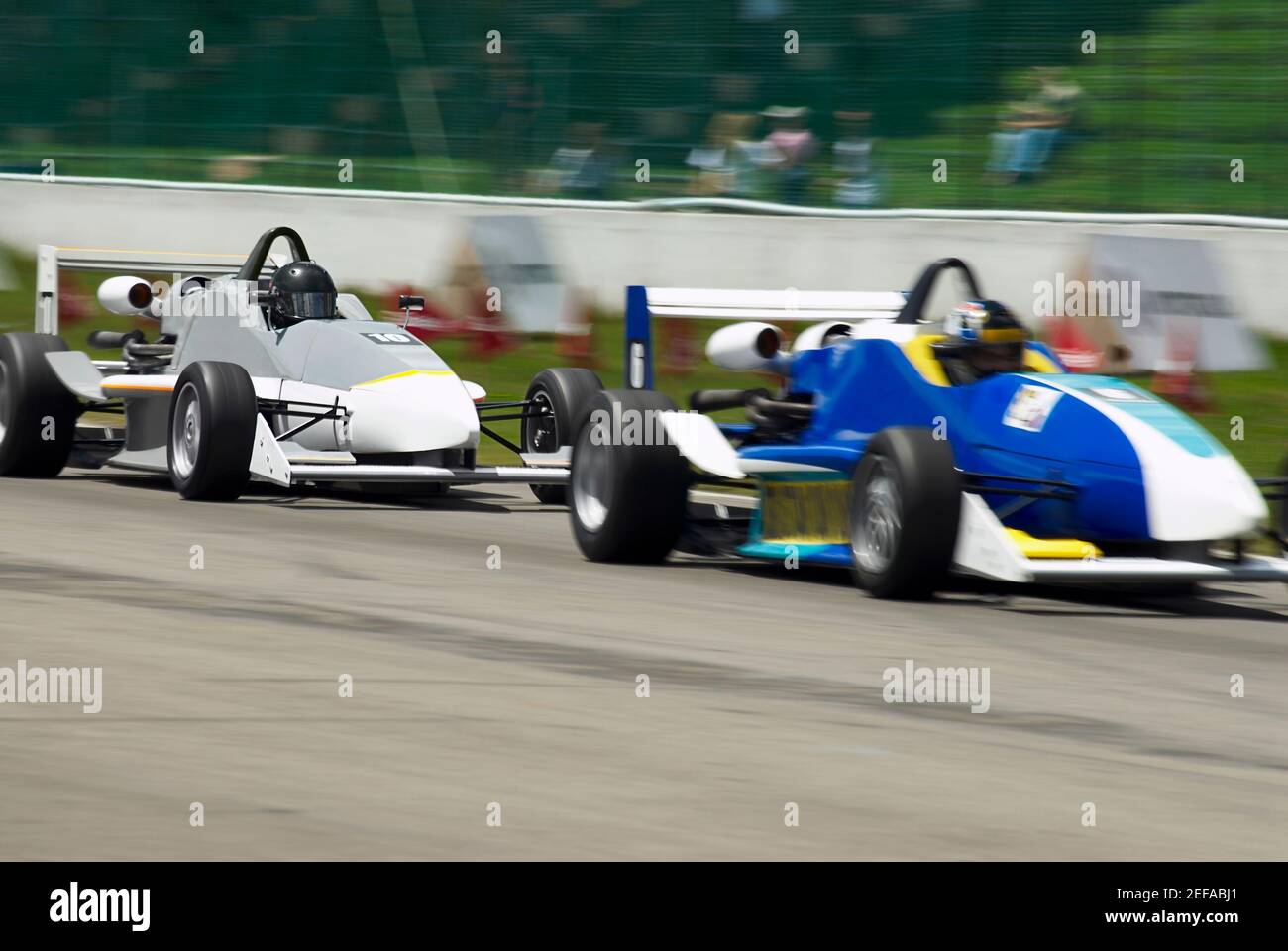 Two racecars racing on a motor racing track Stock Photo - Alamy