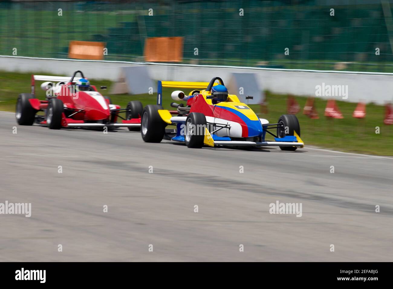 Two racecars racing on a motor racing track Stock Photo - Alamy