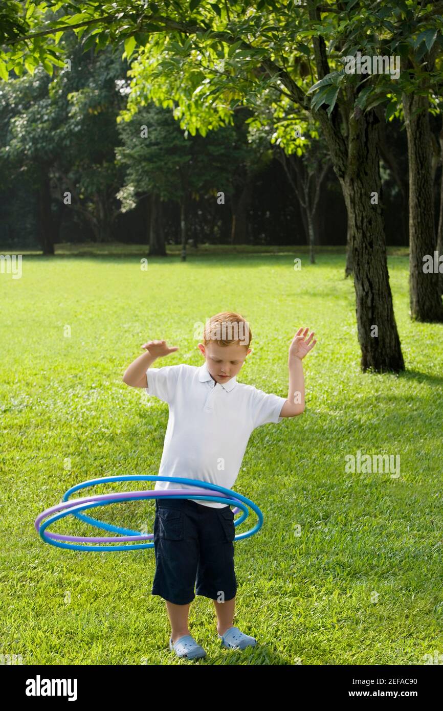 Boy playing with a plastic hoop in a park Stock Photo - Alamy