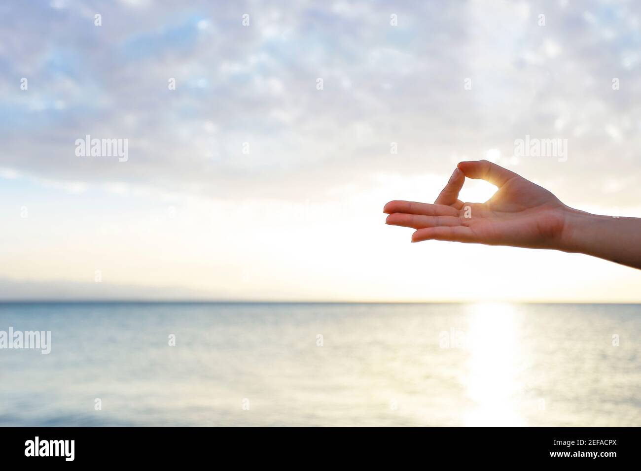 The woman capturing the sunset with fingers frame in Cyprus beach Stock ...