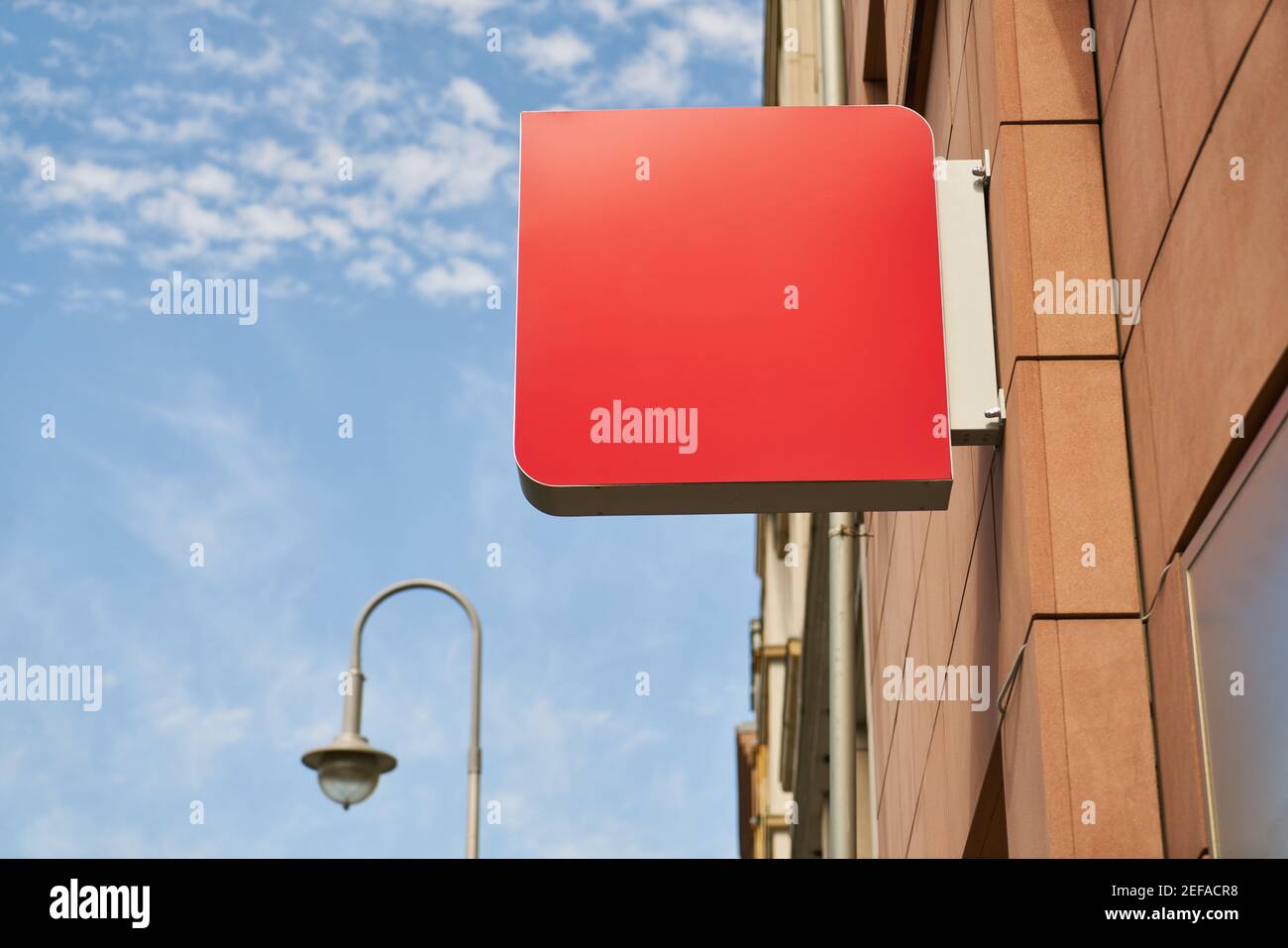 Red sign as a mock-up template on a building for an office or cafe in a ...