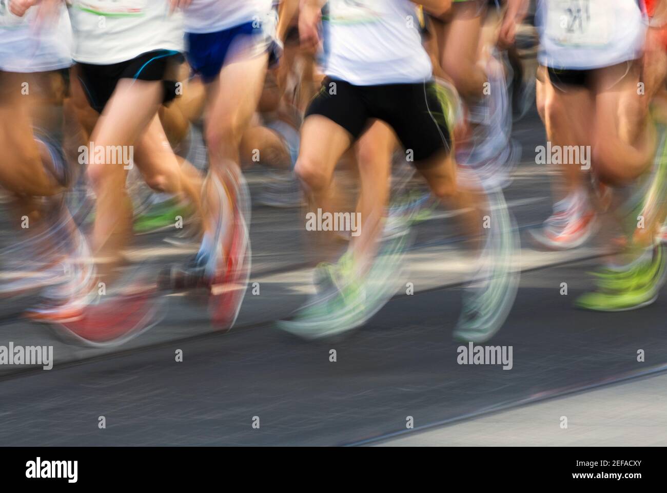 Low section view of male athletes running on a running track Stock ...