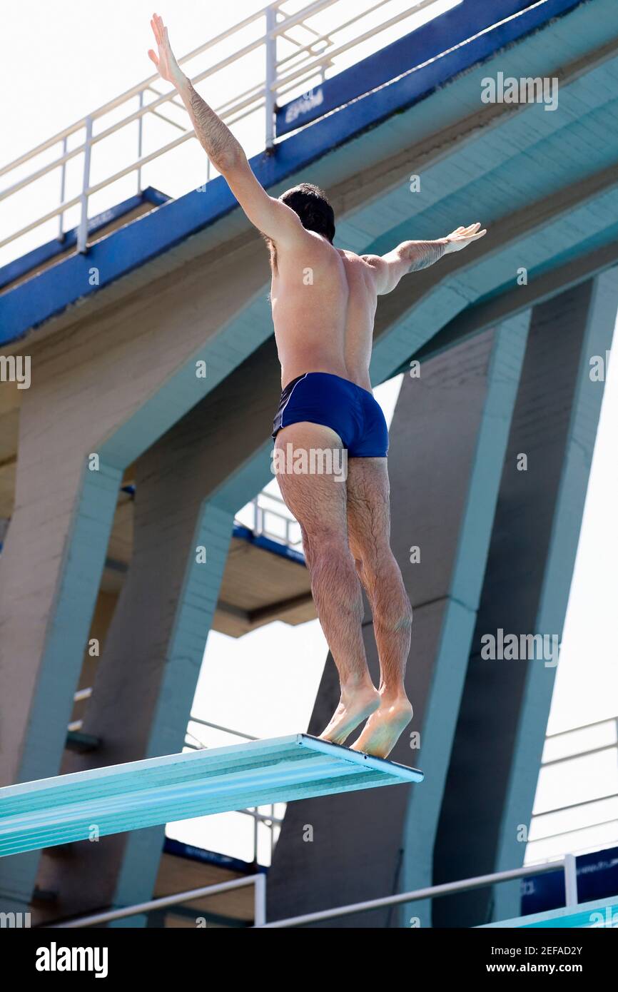 Rear view of a mid adult man taking start from a diving platform Stock ...