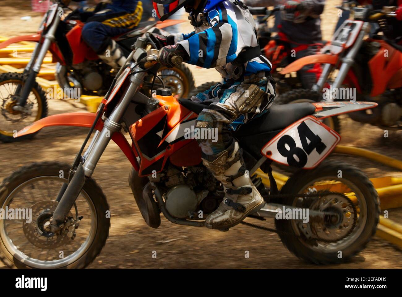 Side profile of motocross riders riding motorcycles Stock Photo - Alamy