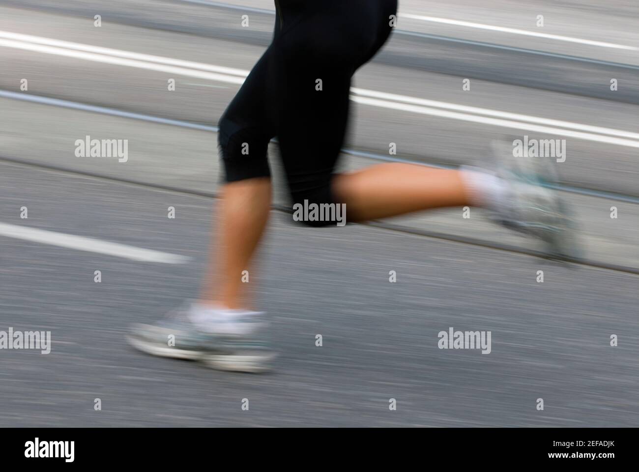 Low section view of a male athlete running on a running track Stock ...