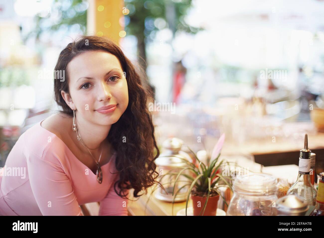Portrait of a young woman sitting in a restaurant Stock Photo - Alamy