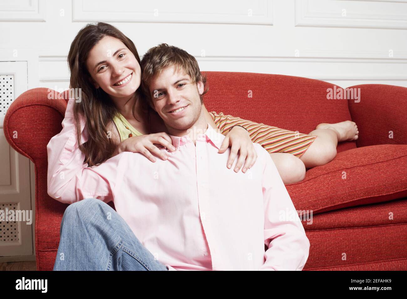Portrait of a young woman leaning over a young man from behind Stock ...