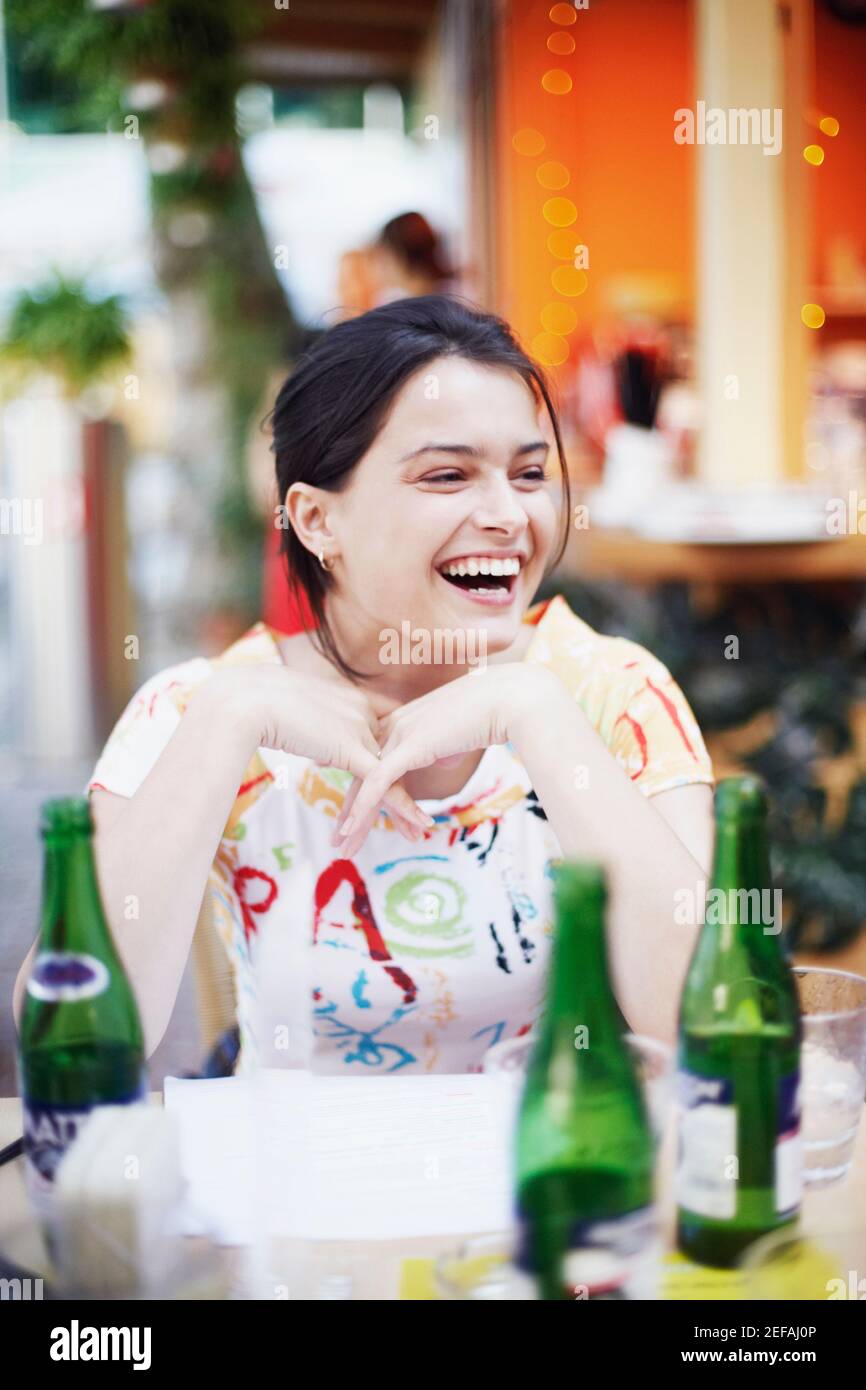 Young woman seated at a table in a restaurant and smiling Stock Photo ...