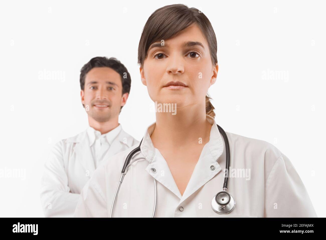 Female doctor thinking with a male doctor smiling behind her Stock ...