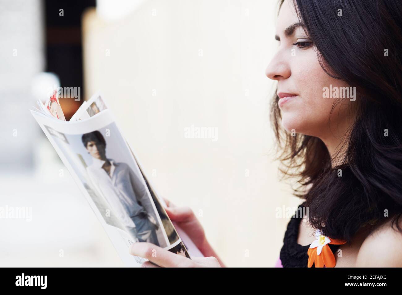 Side profile of a mid adult woman reading a magazine Stock Photo - Alamy