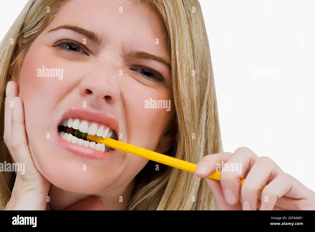 Portrait of a young woman biting a pencil Stock Photo - Alamy