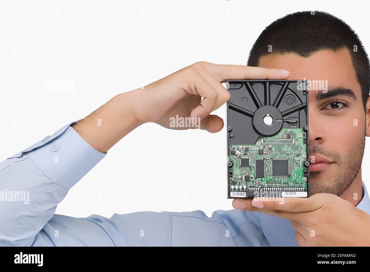 Portrait of a businessman holding a hard drive in front of his face ...