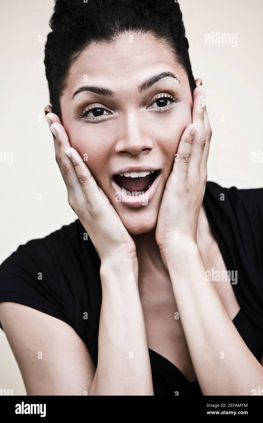 Portrait of a young woman looking surprised Stock Photo - Alamy
